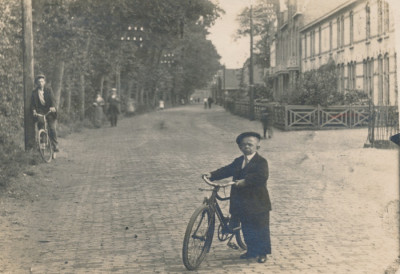 7257 lilliputter met fiets, rechts huizenrij - Zoekplaatjes door Arnold Tak